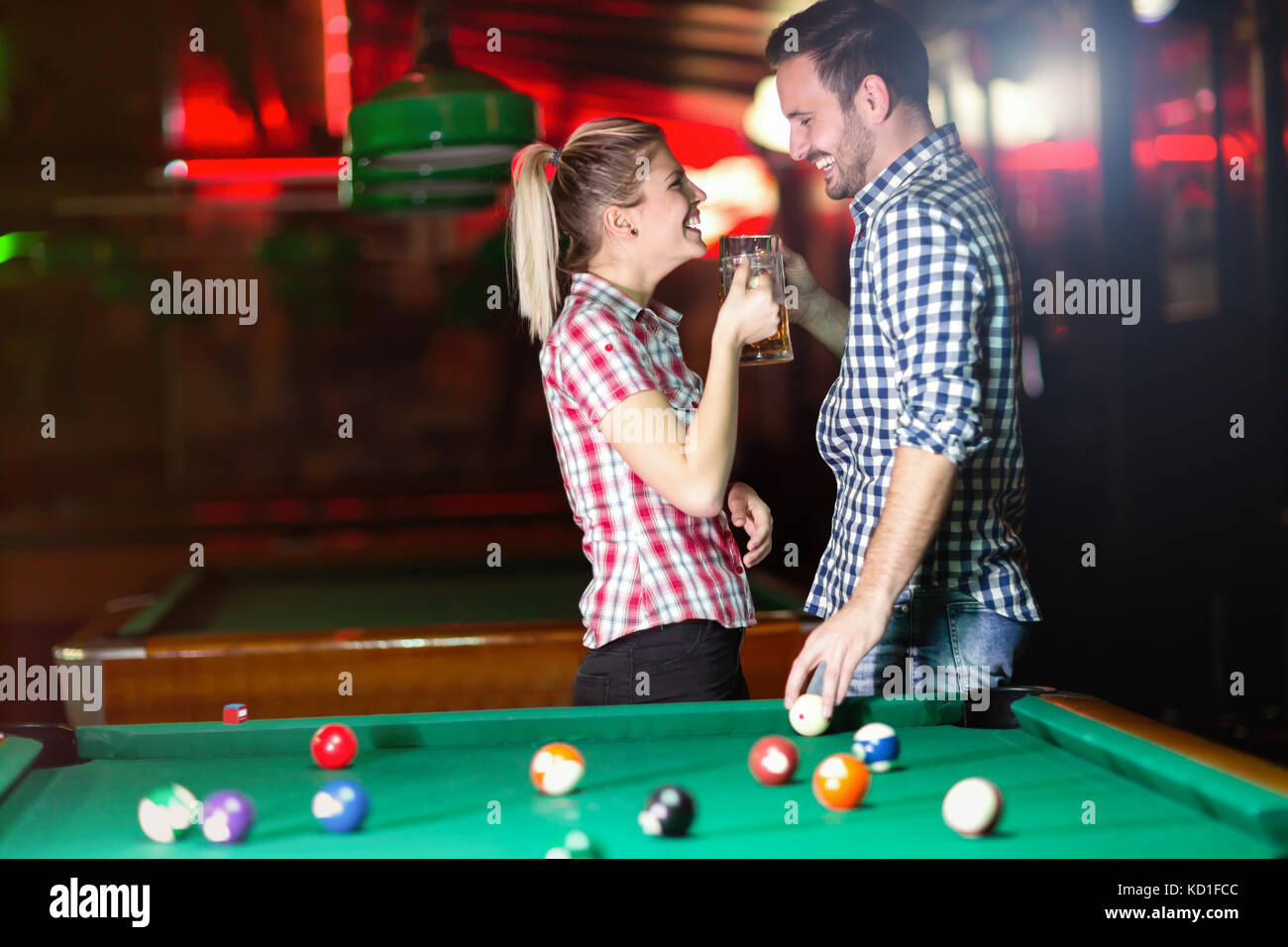 Happy couple drinking beer and playing snooker Stock Photo - Alamy