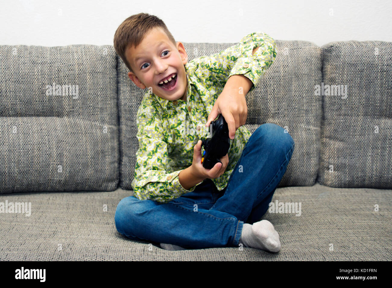 Cute boy playing video games at home Stock Photo - Alamy