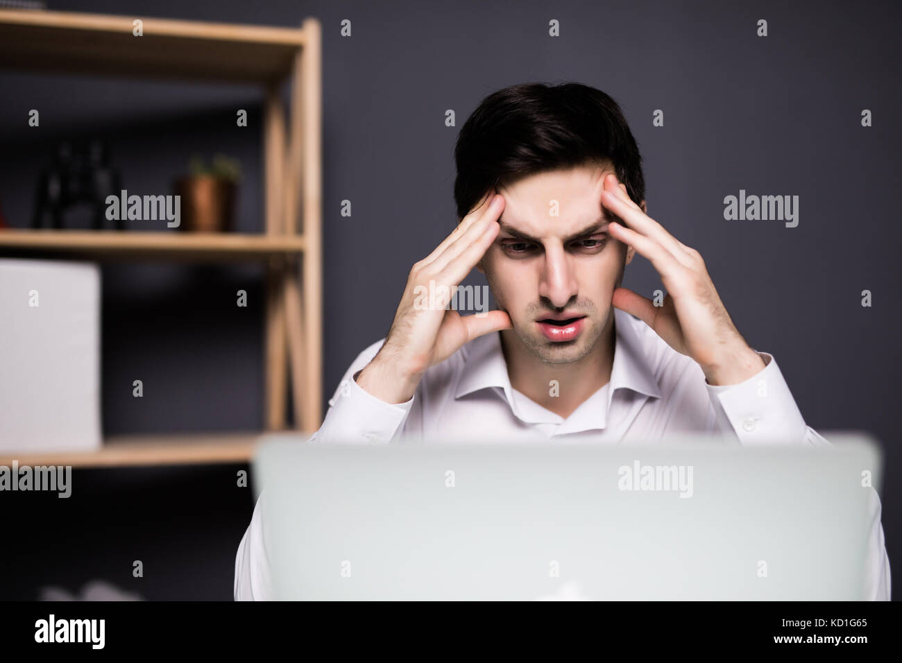 business man working problem using laptop looking at screen, hold head ...
