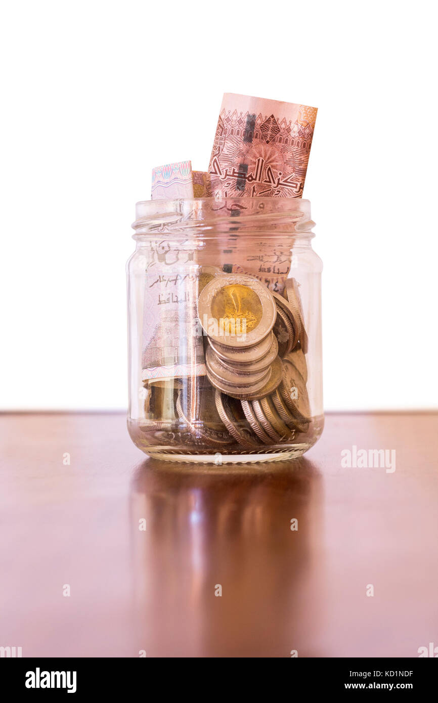 Coins and banknotes in Jar, Egyptian Pounds, on Wooden Desk, Isolated ...