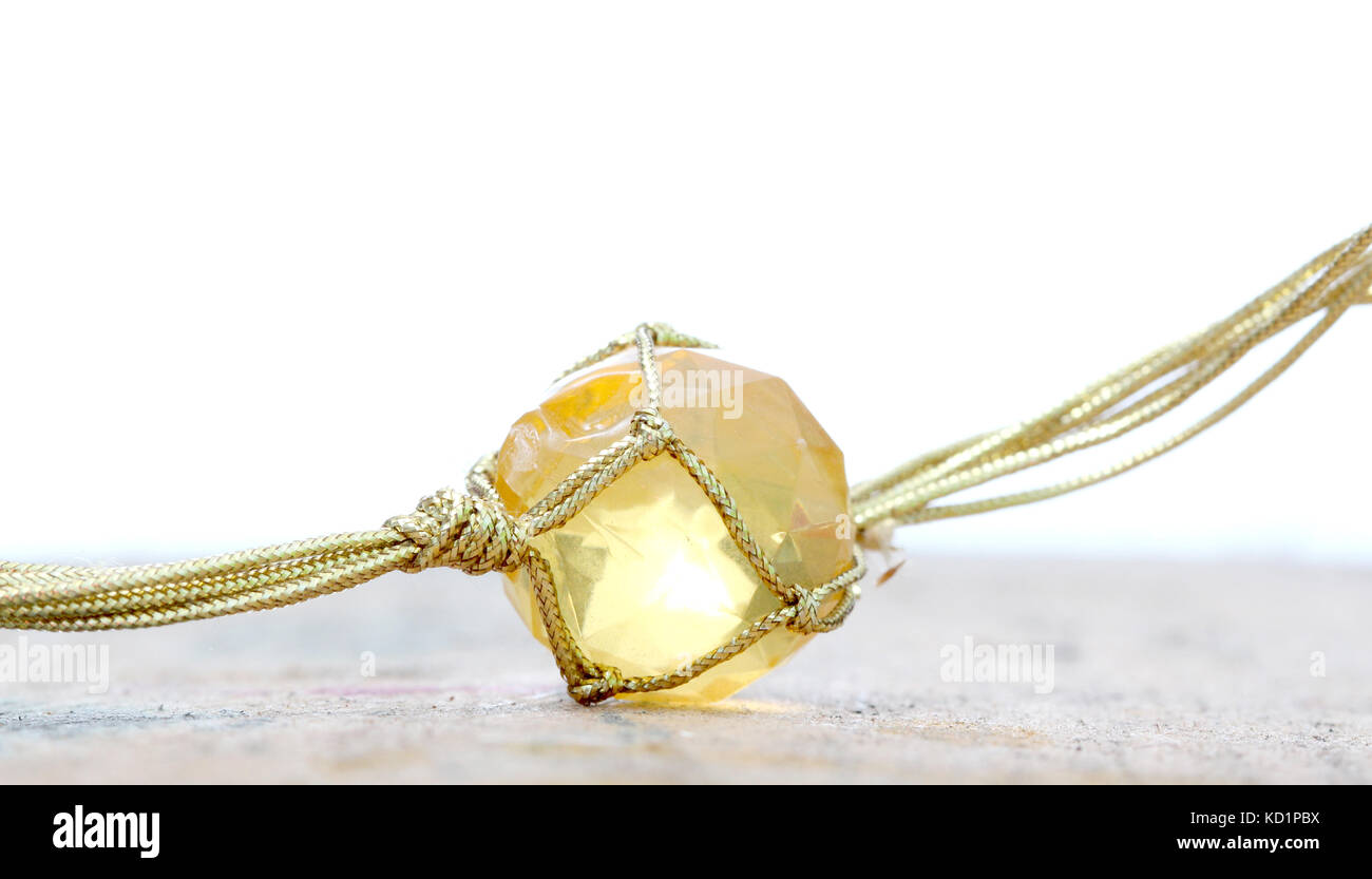 picture of a necklace with cheap plastic gems with golden colored rope ...