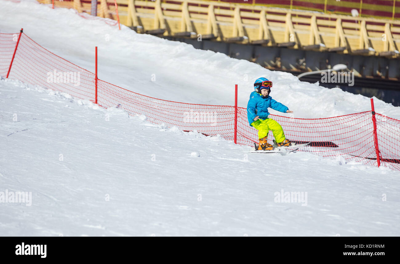 Little boy falling down while skiing in children's area on winter ...