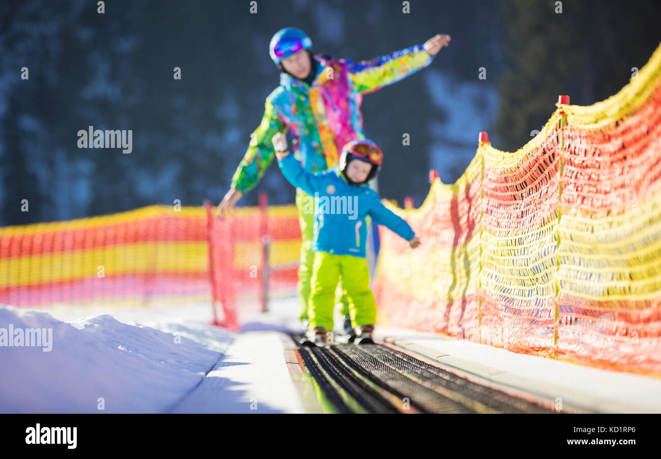 Young boy and his father standing on travelator in children's area ...