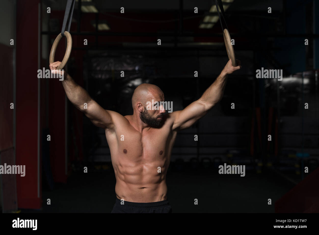 Adult Man Exercising While Holding Large Gymnastic Rings At The Gym ...
