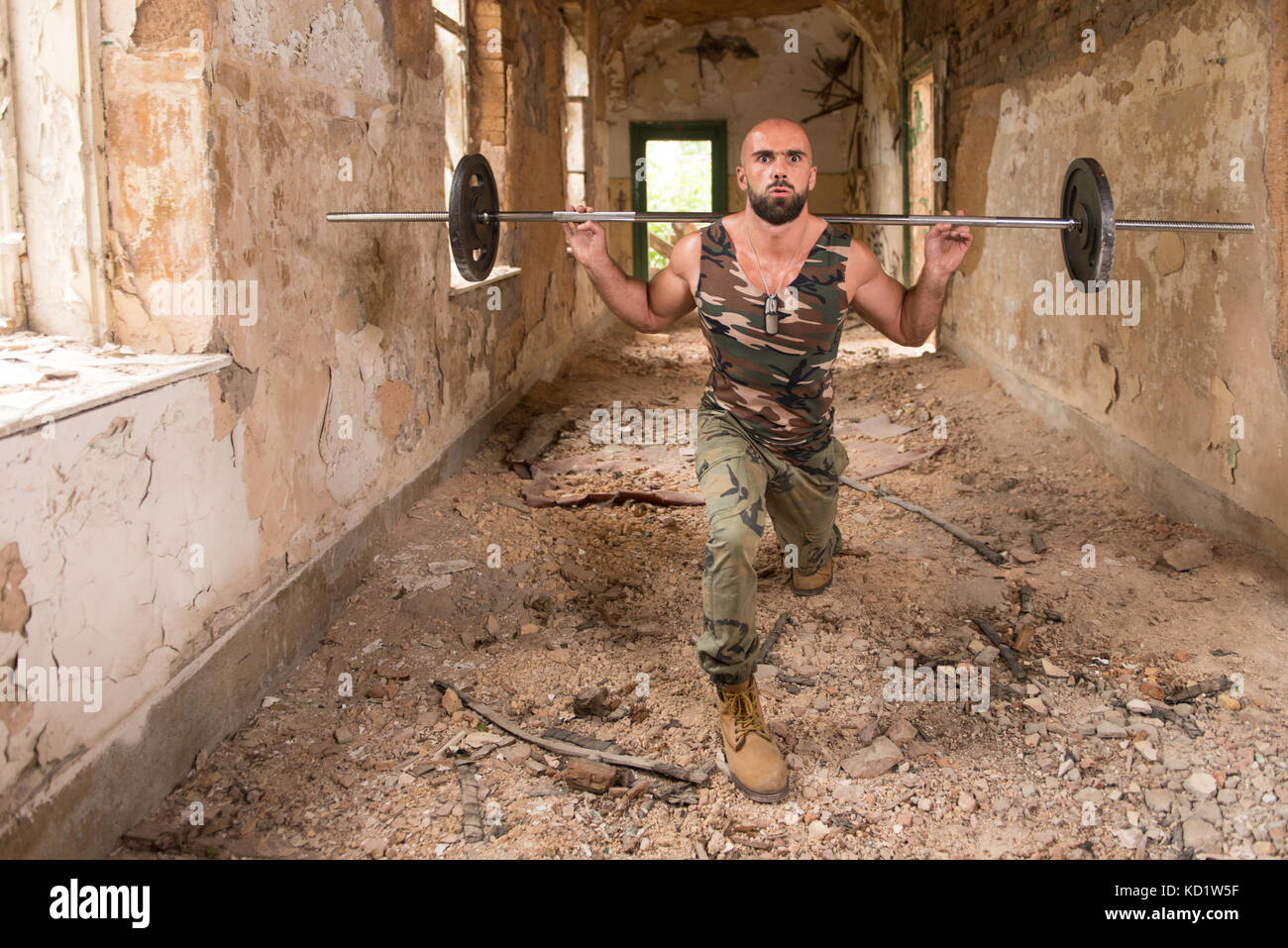 Athlete In Army Pants Working Out Legs Inside Shelter With Barbell ...