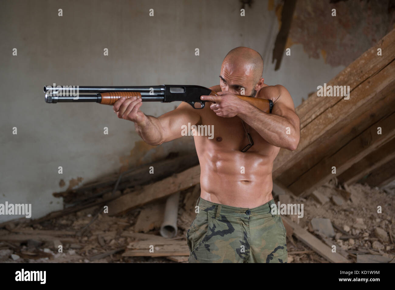 Action Hero Muscled Man Holding Machine Gun - Standing In Abandoned ...