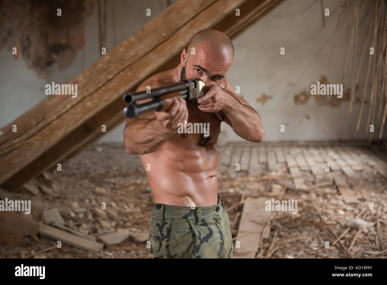 Action Hero Muscled Man Holding Machine Gun - Standing In Abandoned ...