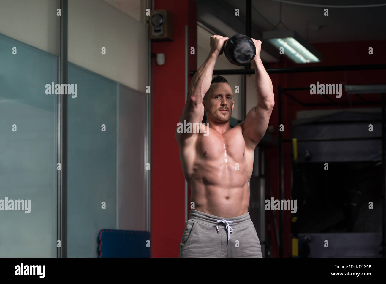 Young Man Working Out With Kettle Bell In A Dark Gym - Bodybuilder ...