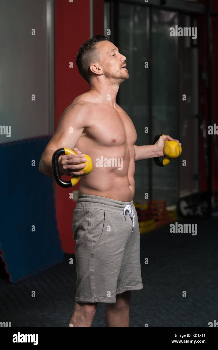 Young Man Working Out With Kettle Bell In A Dark Gym - Bodybuilder ...
