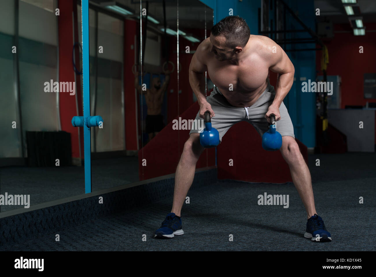 Young Man Exercising With Kettle Bell And Flexing Muscles - Muscular ...