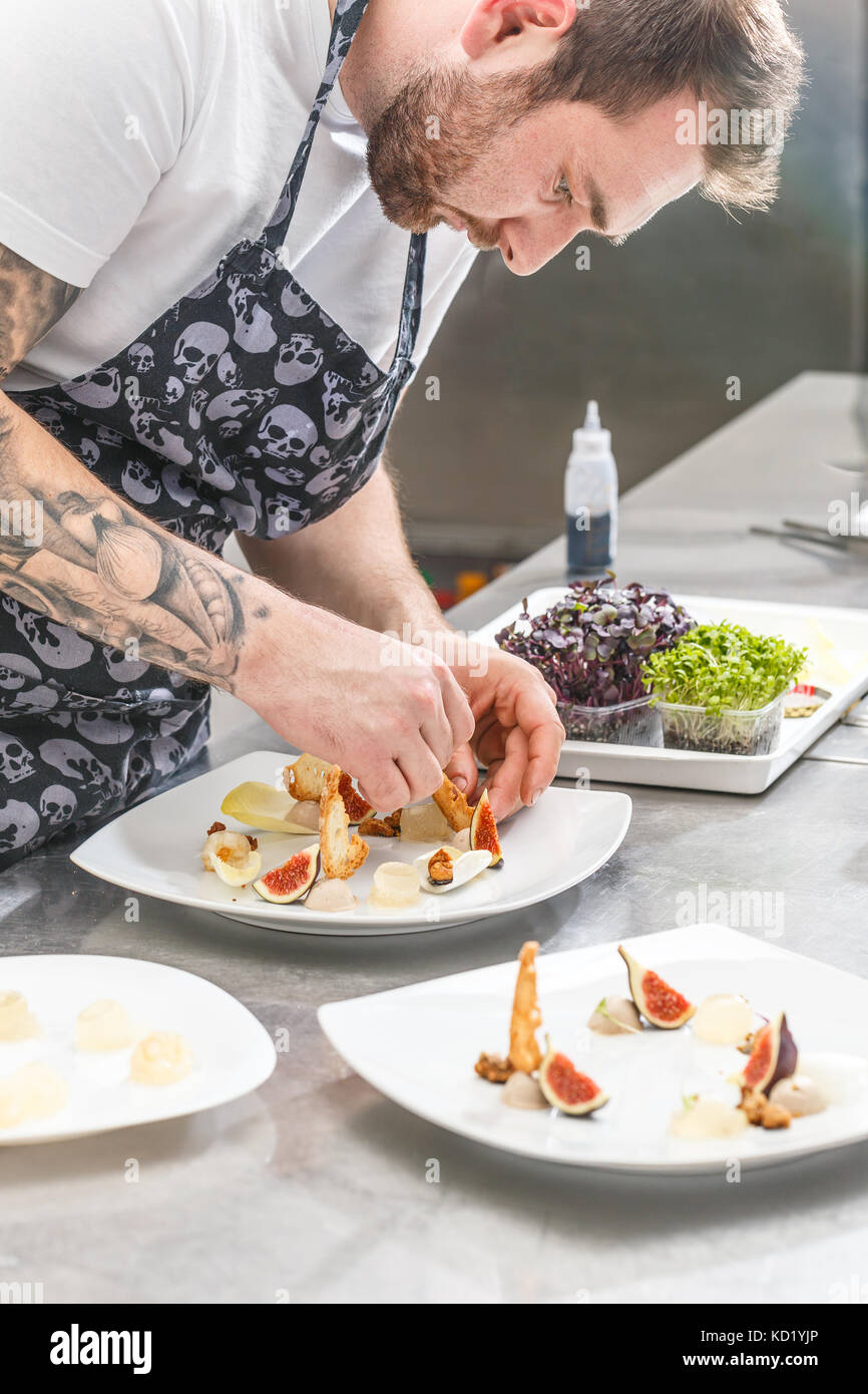 Chef finishes his plate and almost ready to serve at the table Stock ...