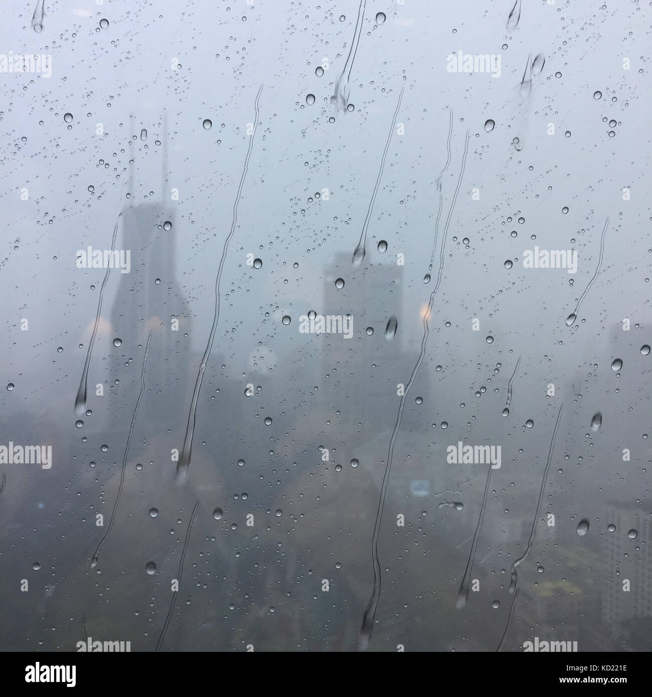 Rain drips across a window as we look out upon a modern day Shanghai ...