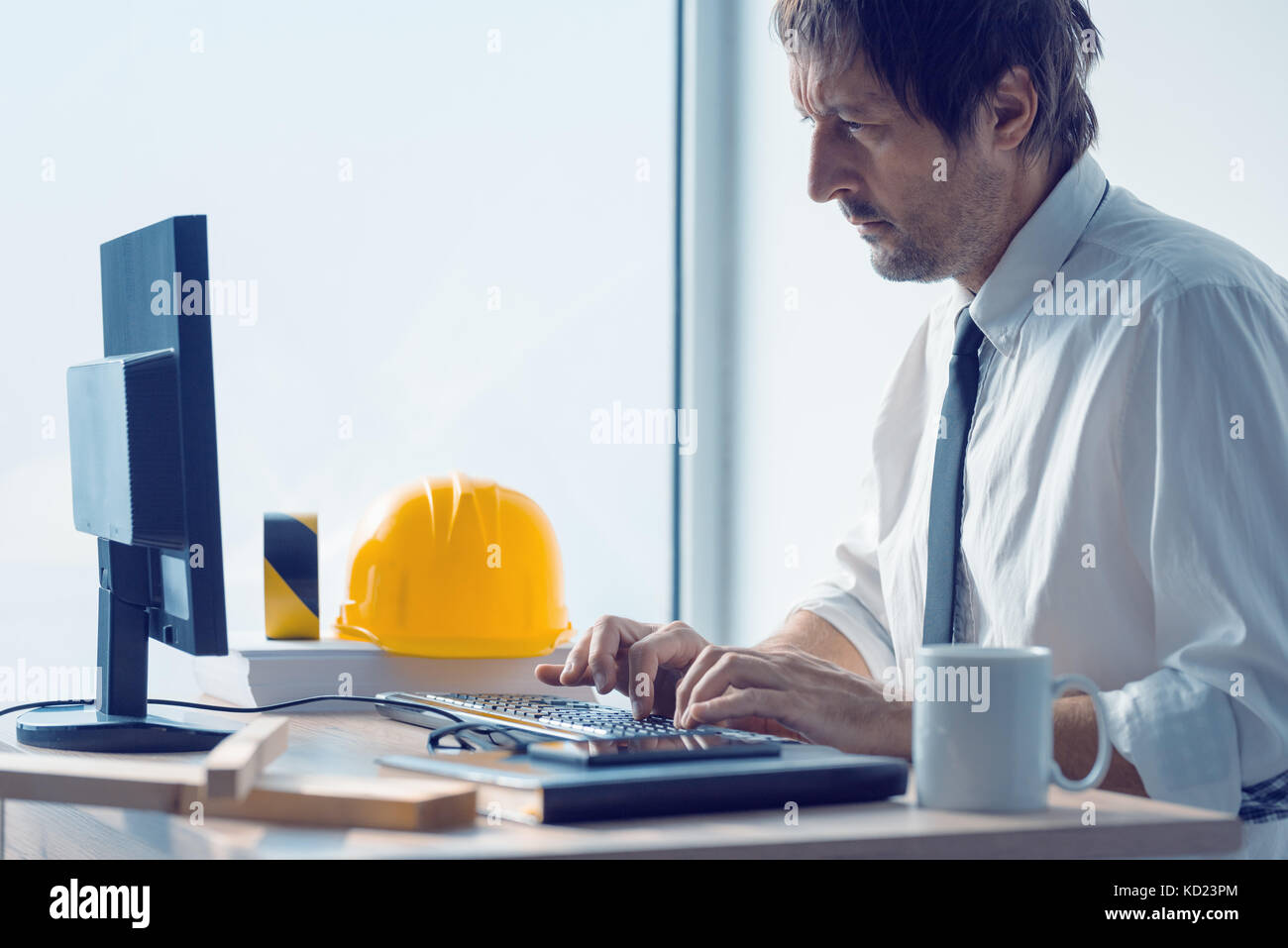 Construction engineer working on desktop computer using CAD software to ...