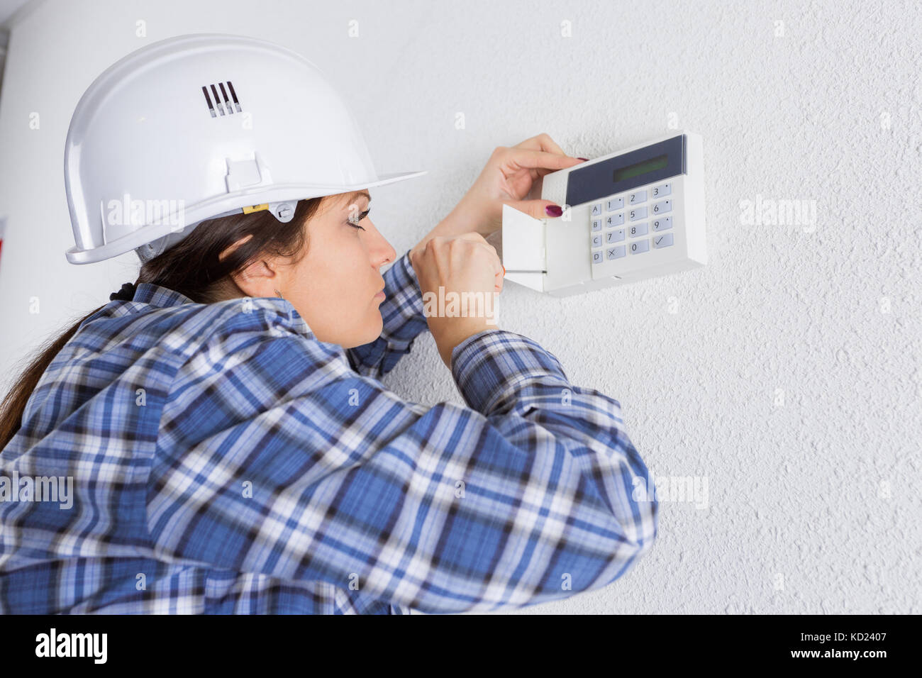Contractor fixing keypad to wall Stock Photo - Alamy