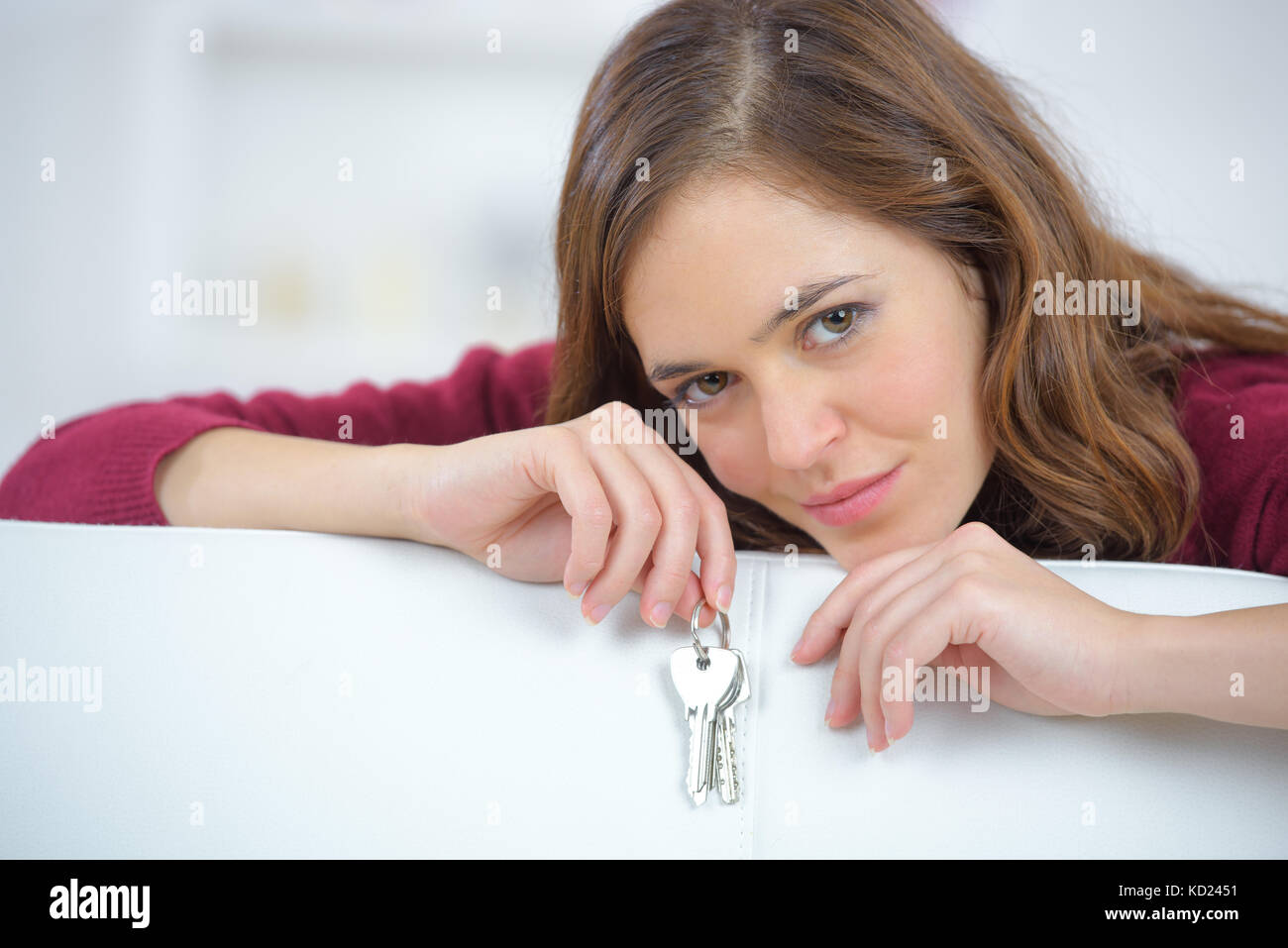 woman on sofa holding keys Stock Photo - Alamy
