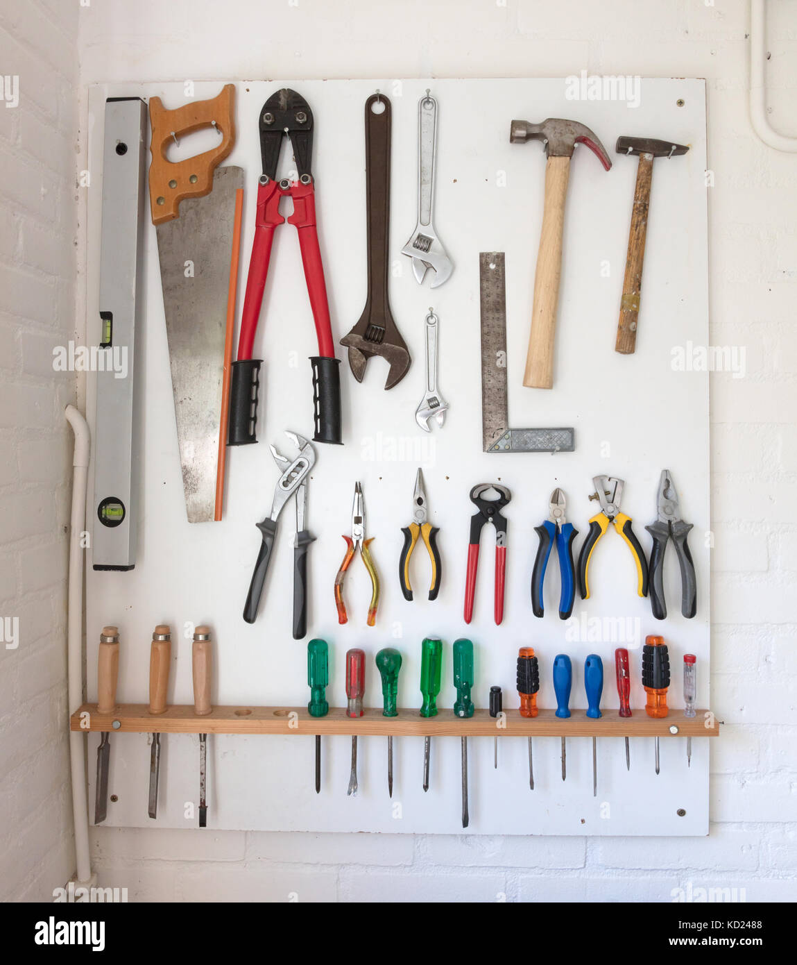 Assorted tools on a white tool board - Simple setting Stock Photo - Alamy