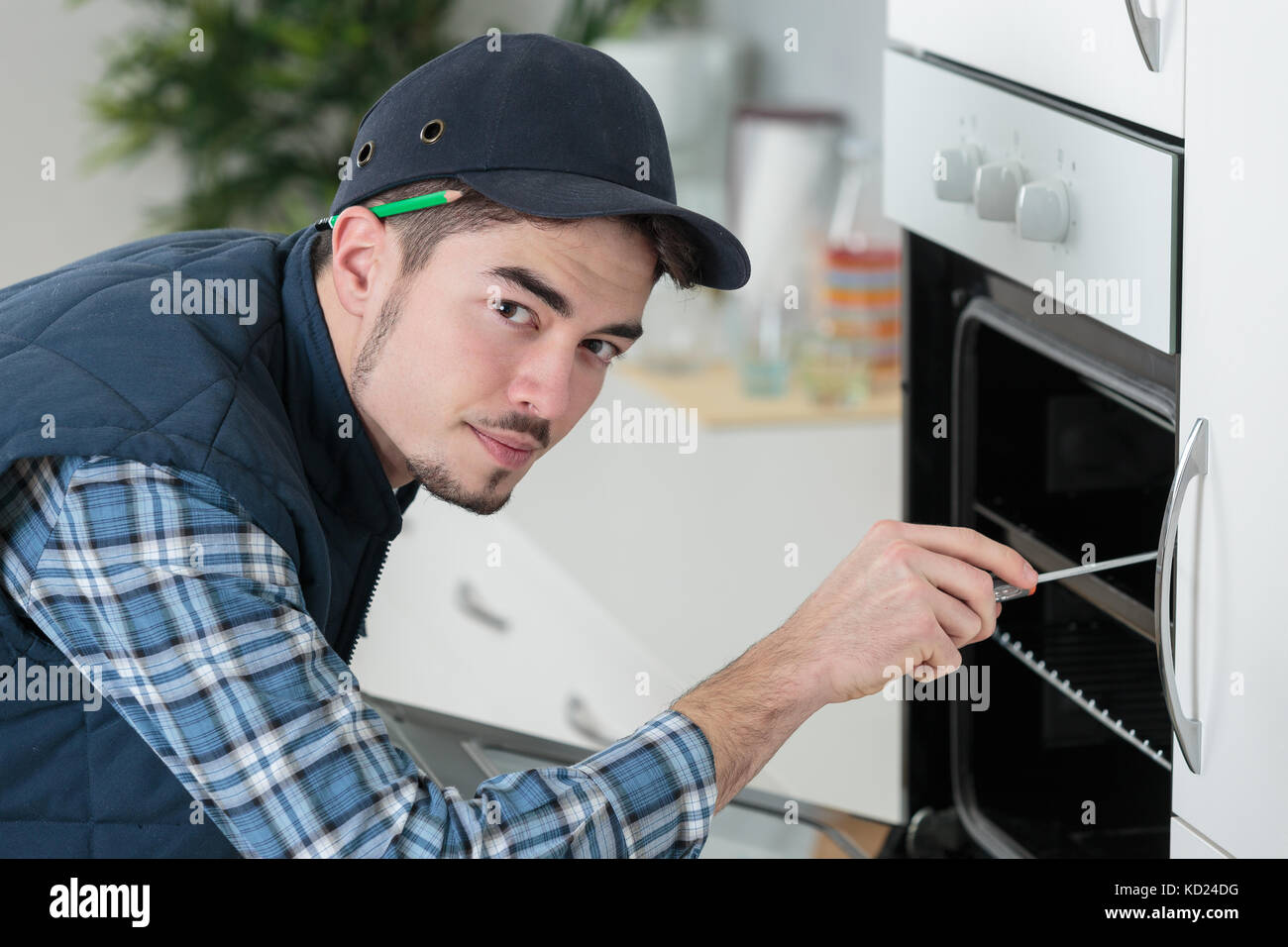 Portrait of man fitting new oven Stock Photo - Alamy