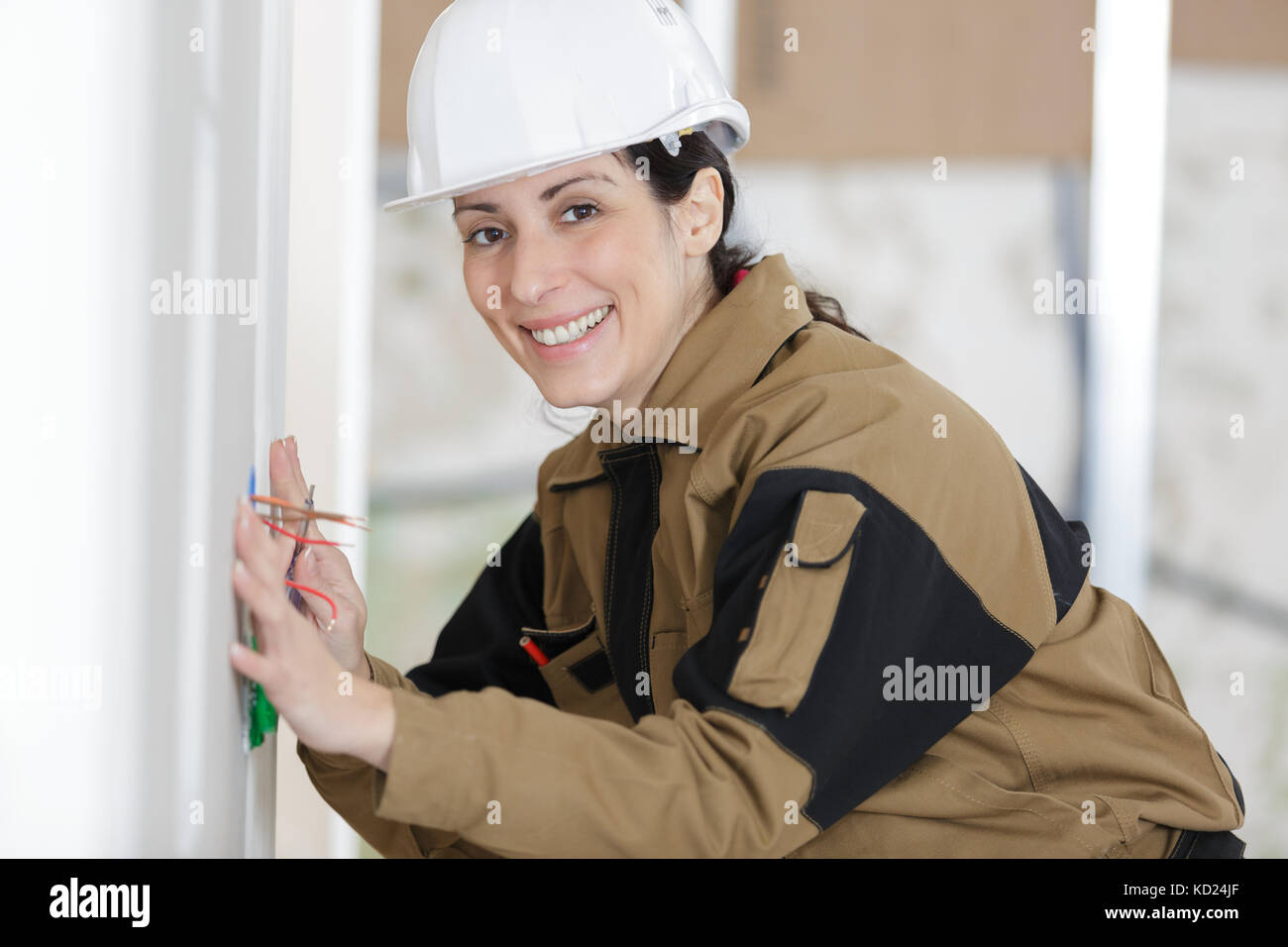female builder checking work with spirit level Stock Photo - Alamy