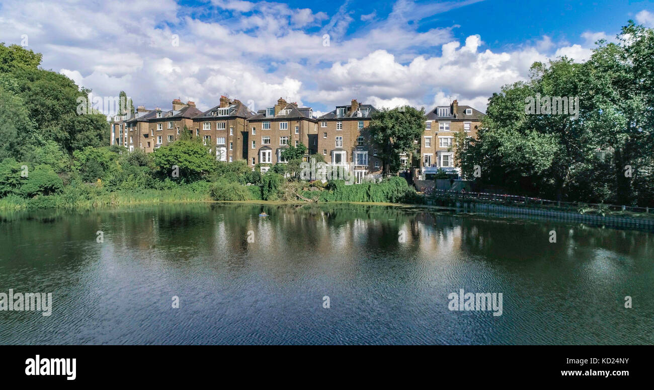Aerial view of Victorian houses reflecting on a pond in a park in North ...