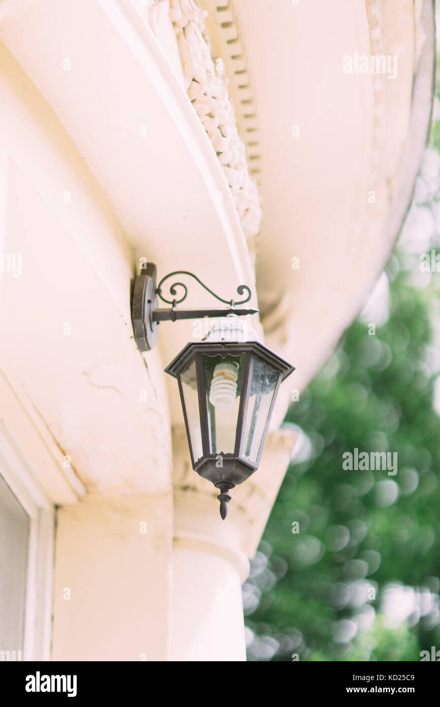 The side view of the black vintage wall lamp on the ancient building ...