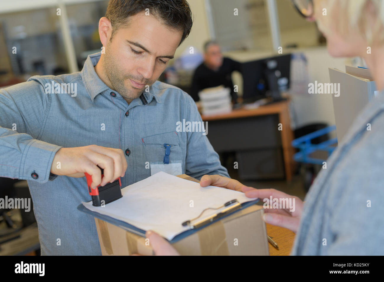 employee stamping document given by delivery man Stock Photo - Alamy
