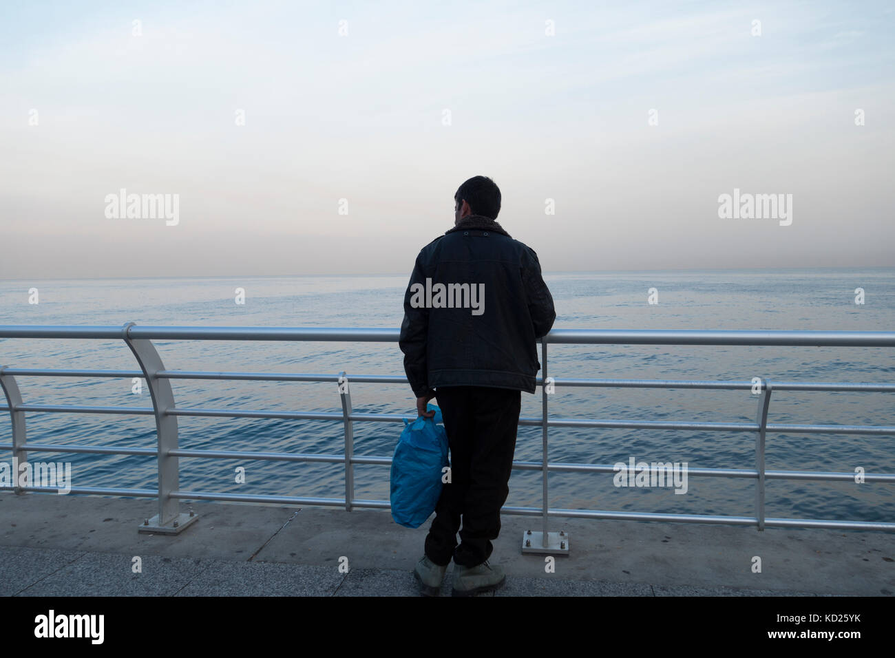 Rear view of a man standing by the sea Stock Photo - Alamy