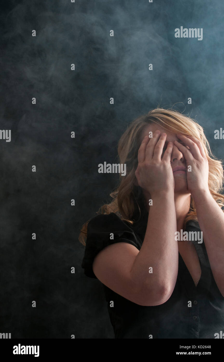 Woman hiding face with hands in fear Stock Photo - Alamy