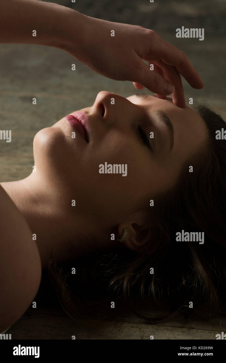 Stressed young woman laying down on the floor hand over forehead Stock ...