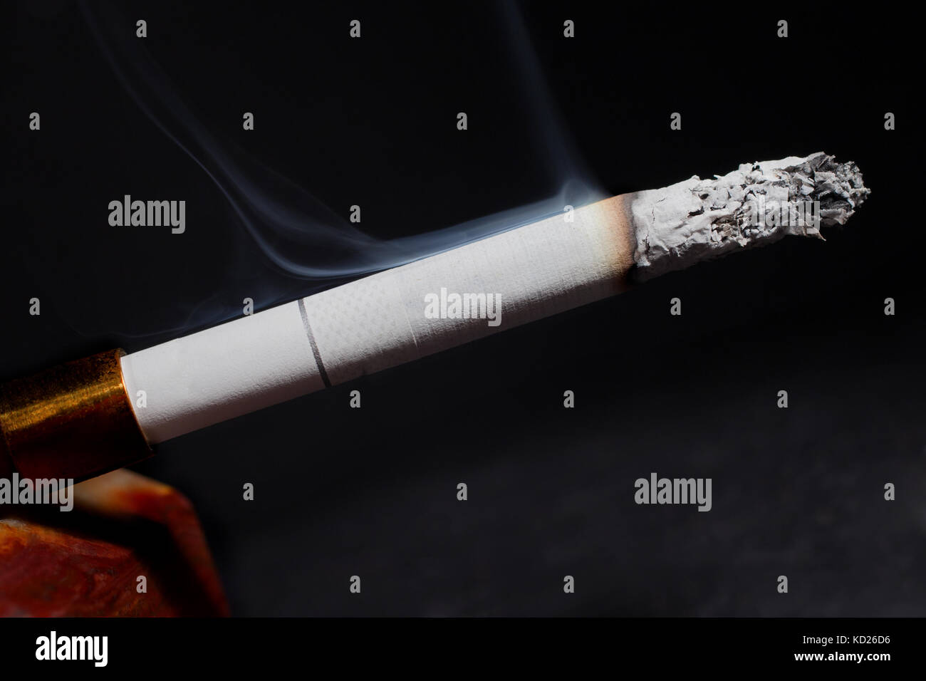A smoking white cigarette on black background macro Stock Photo - Alamy