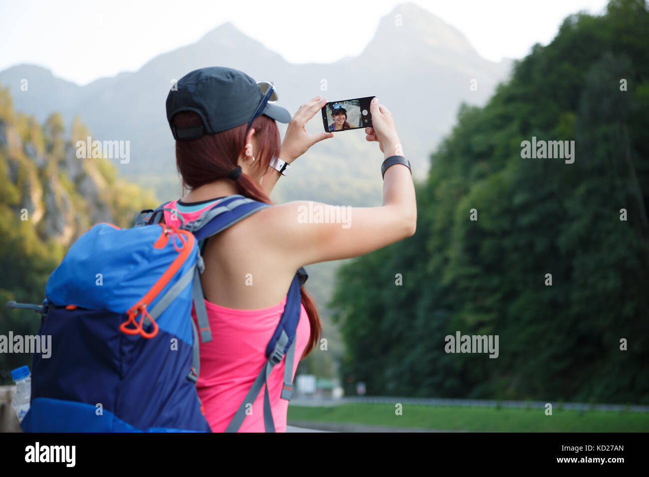 Image from back of tourist woman photographing mountain Stock Photo - Alamy