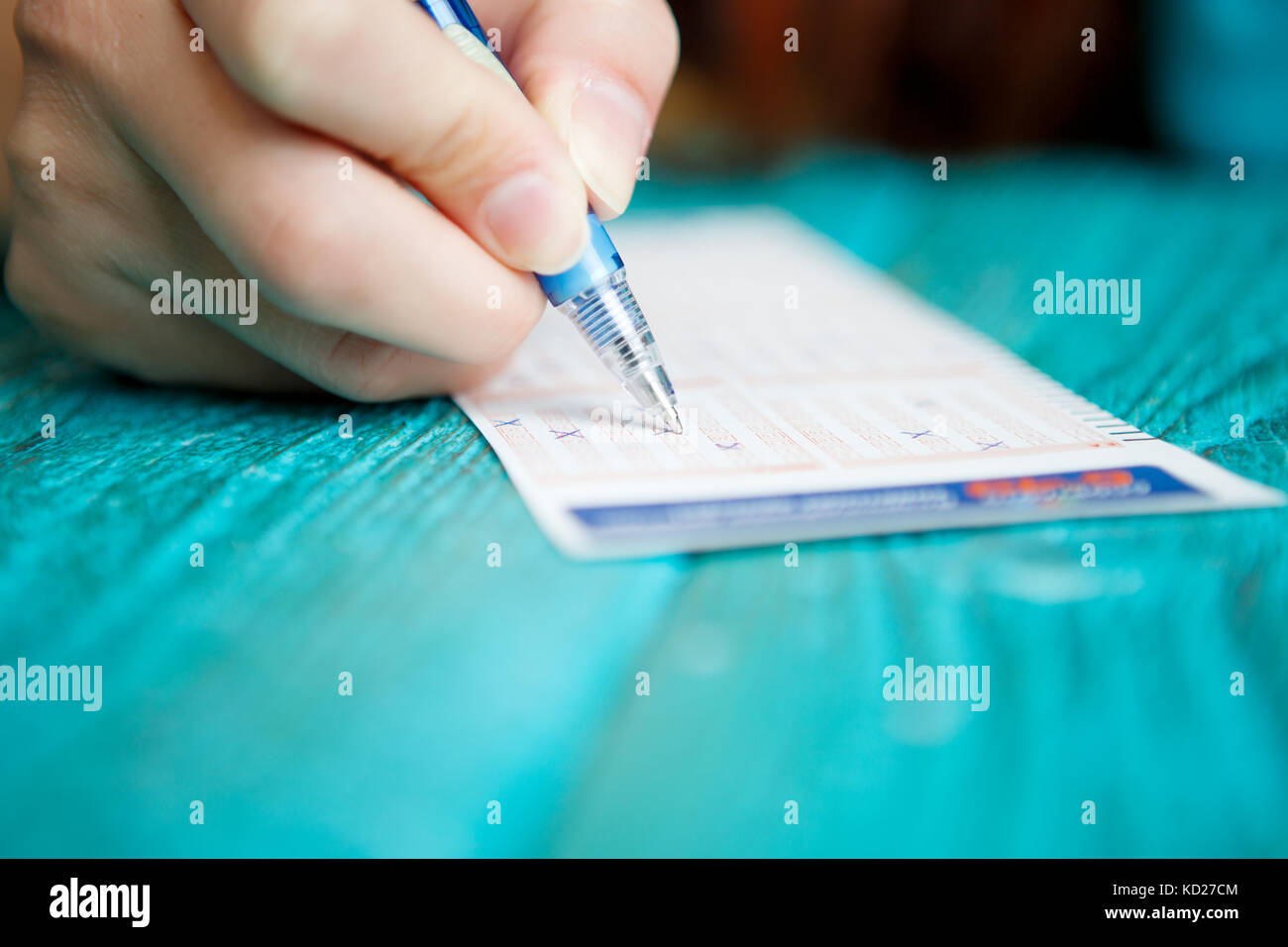 Photo of man's hand with pen and lottery ticket Stock Photo - Alamy