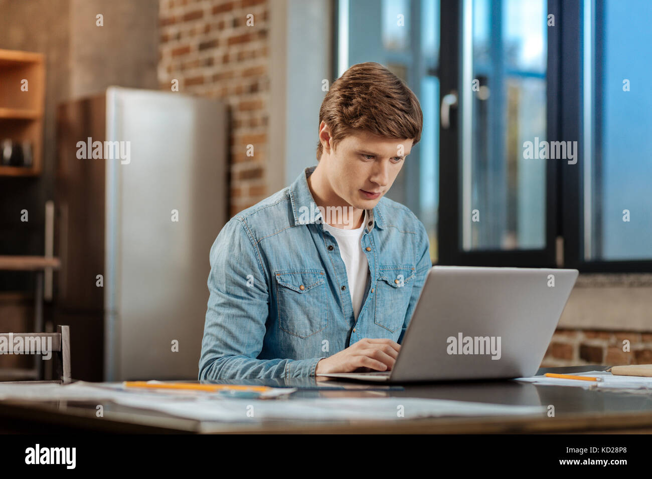 Pleasant young man working on the laptop Stock Photo - Alamy