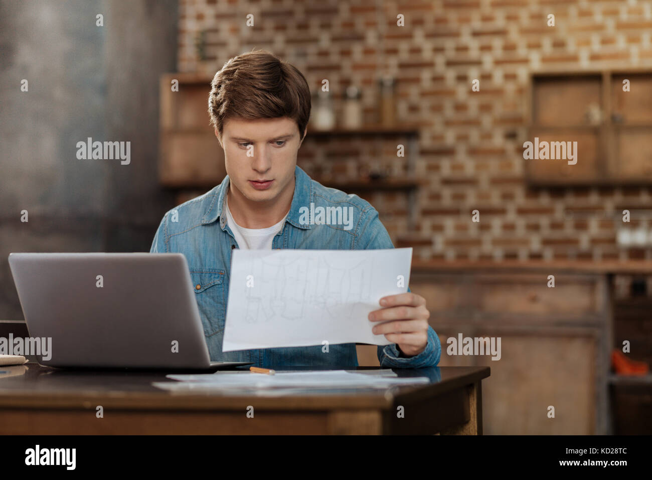 Handsome young man studying the blueprint Stock Photo - Alamy