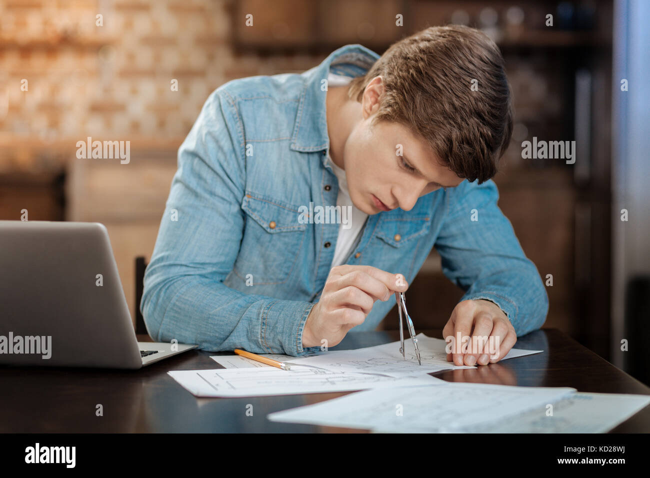 Young man drawing blueprint with a pair of compasses Stock Photo - Alamy