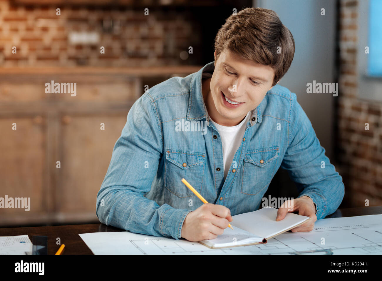 Pleasant young engineer making notes Stock Photo - Alamy