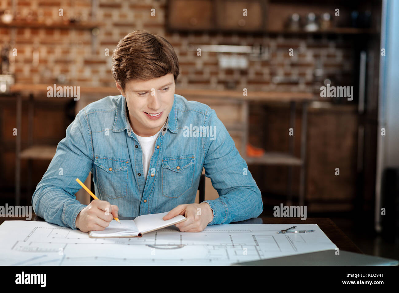Cheerful young engineer doing calculations for his project Stock Photo ...