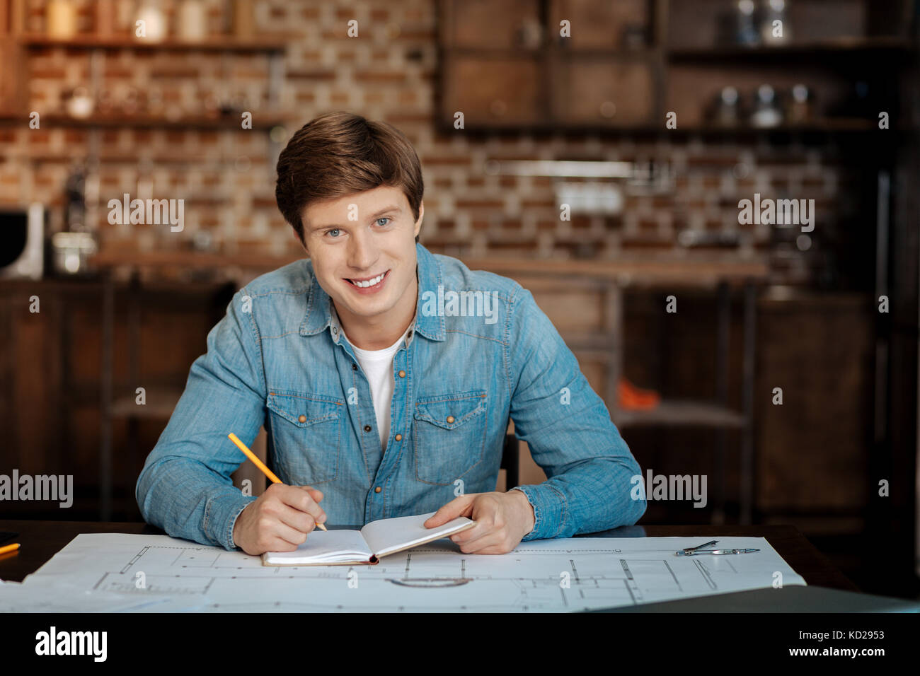 Handsome man posing while doing project calculations Stock Photo - Alamy