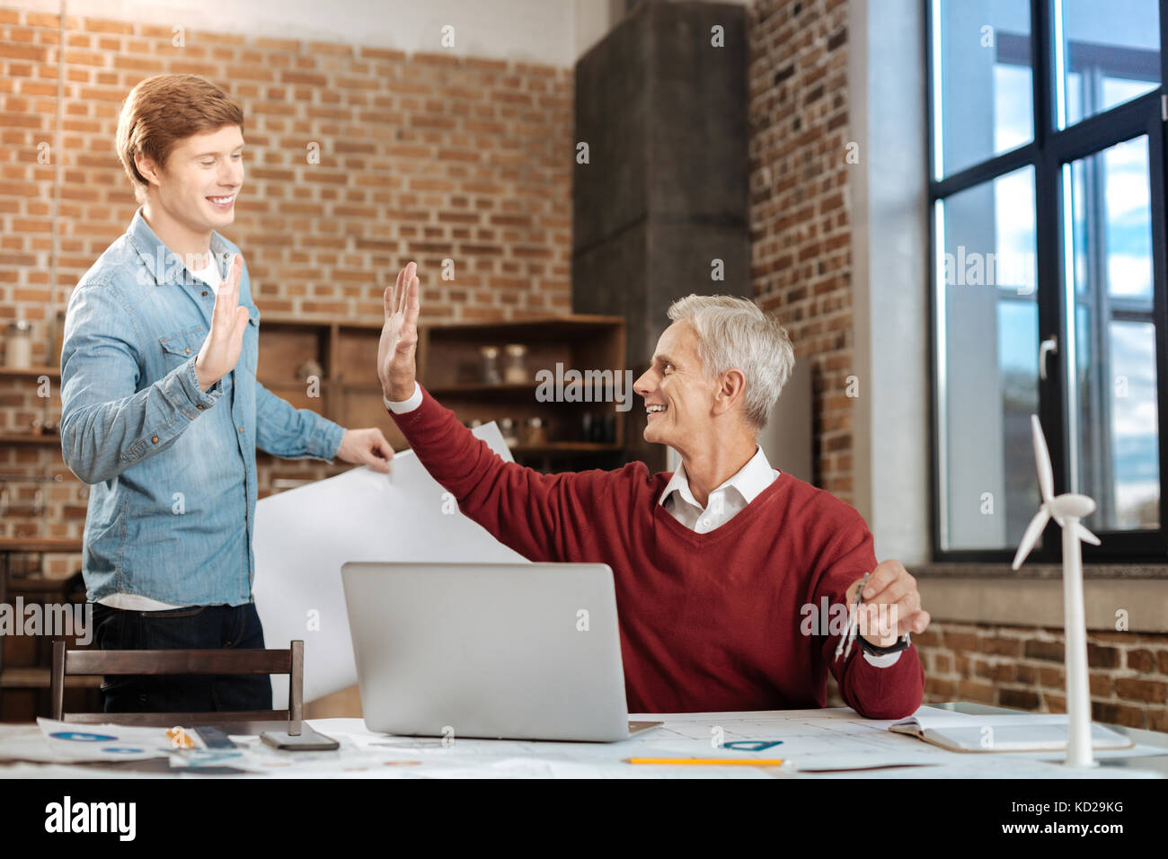 Professional colleagues high fiving hi-res stock photography and images ...