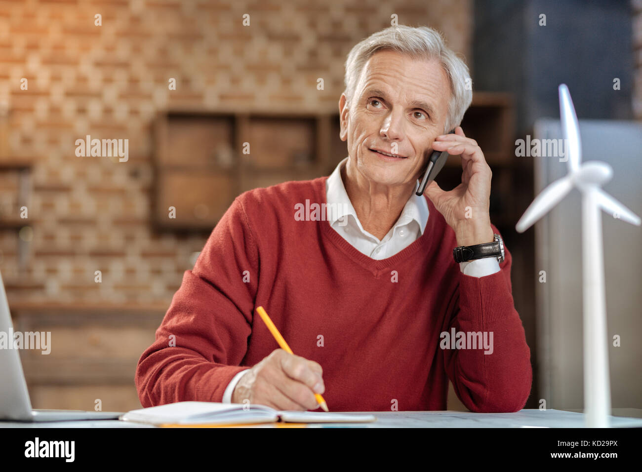 Senior man making notes while talking on the phone Stock Photo - Alamy