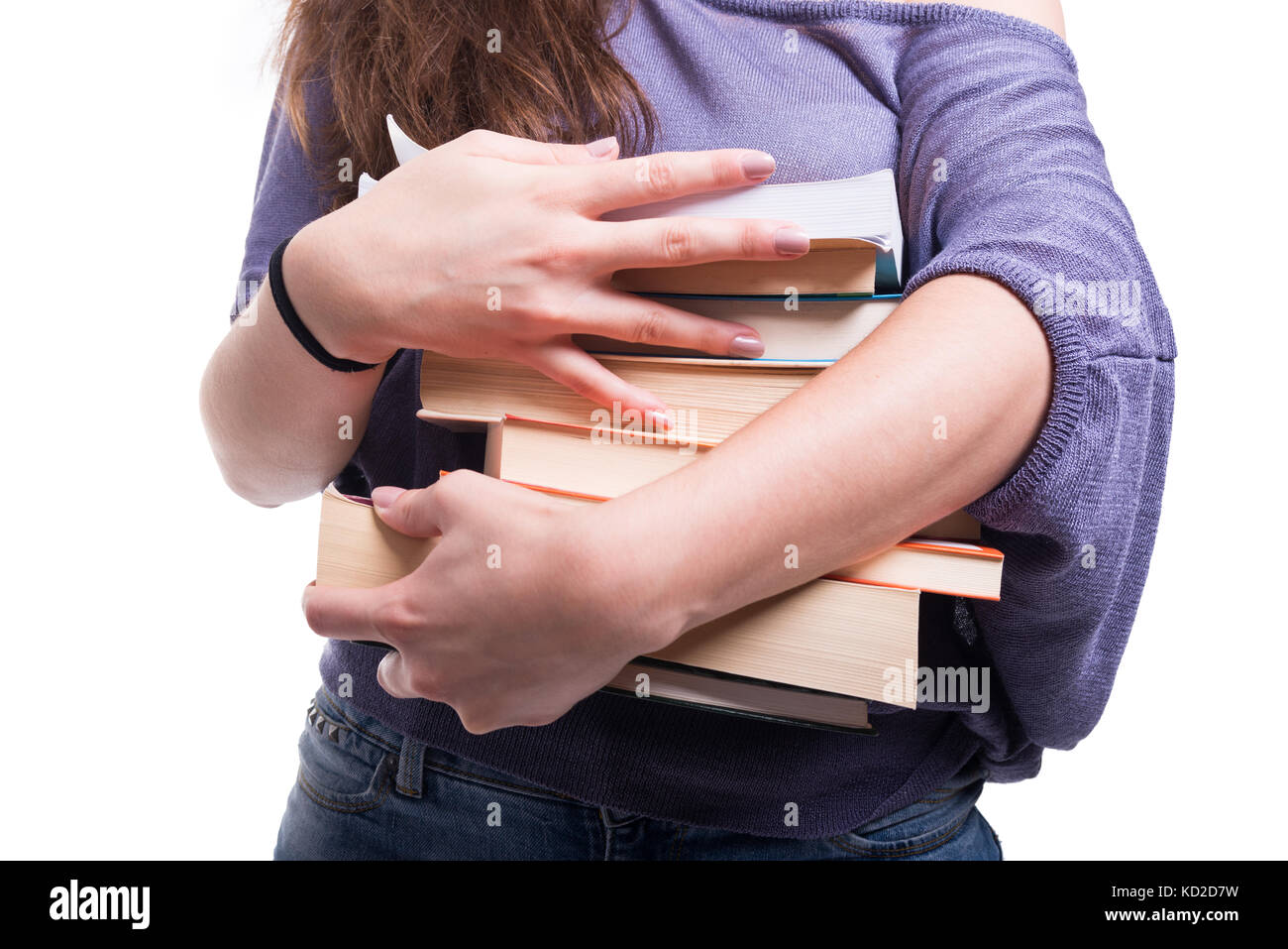 Female student carrying a pile of books to the library after learning ...