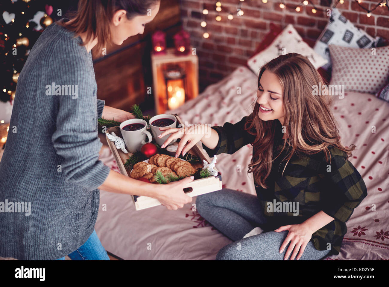 Girl sharing cookies and mulled wine with her friend Stock Photo - Alamy