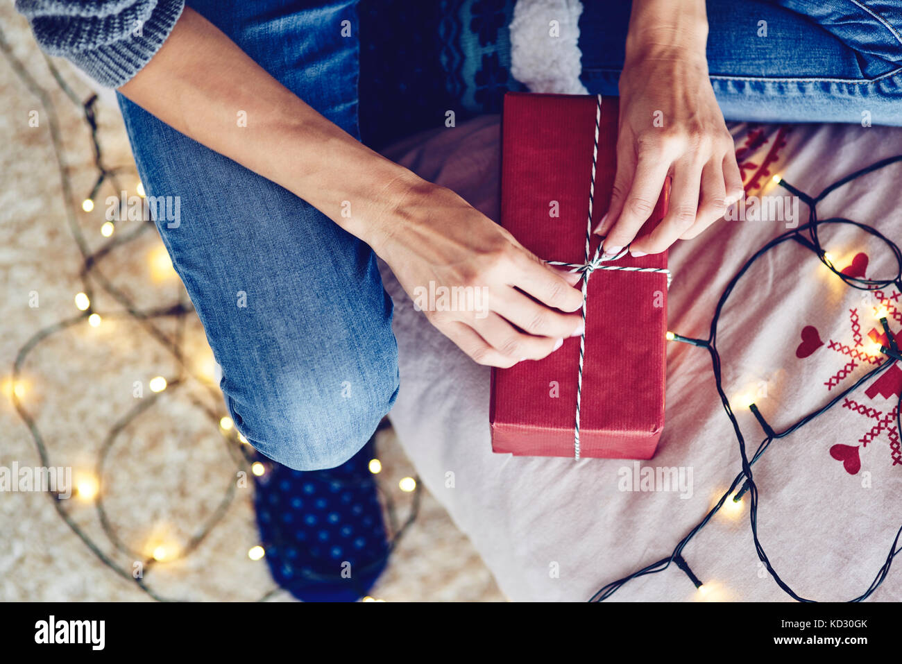Human hand tying a string on a gift Stock Photo - Alamy