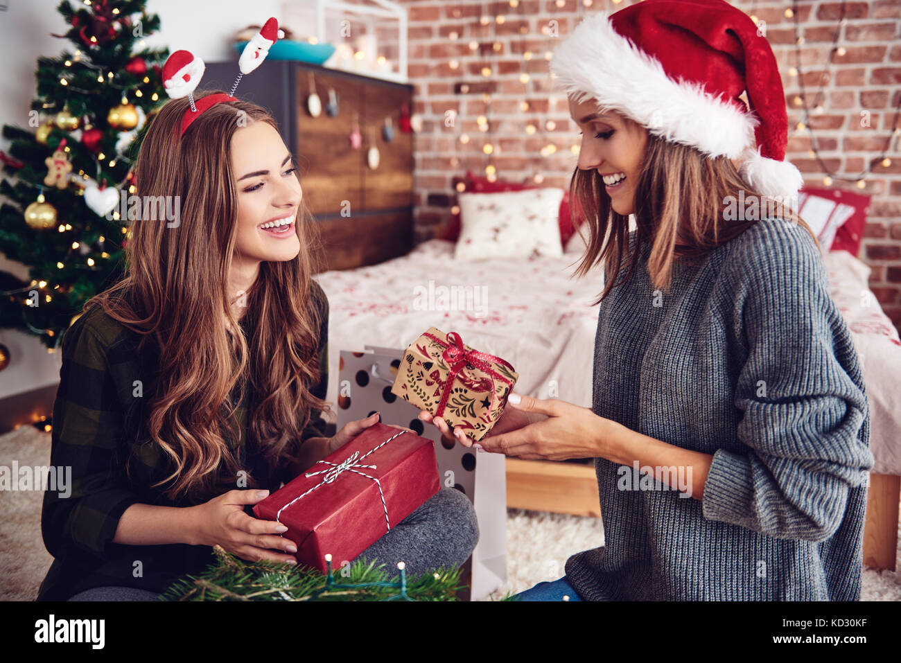 Friends presenting gifts each other in bedroom Stock Photo - Alamy