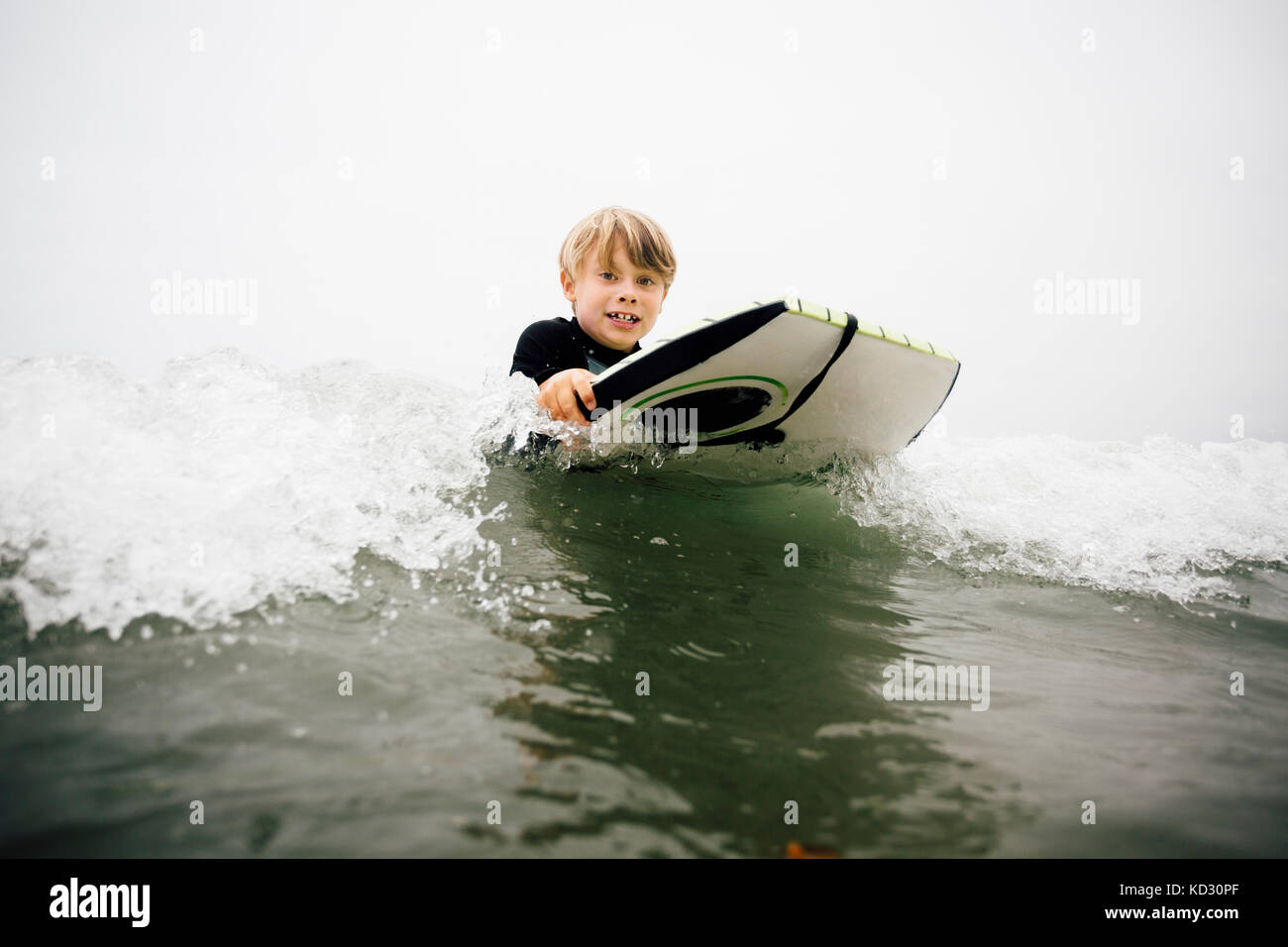 Young boy bodyboarding in sea Stock Photo - Alamy