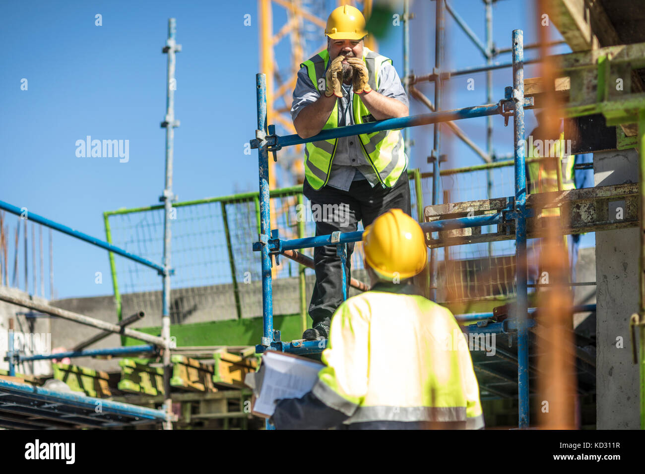 Construction workers in discussion on building site Stock Photo - Alamy