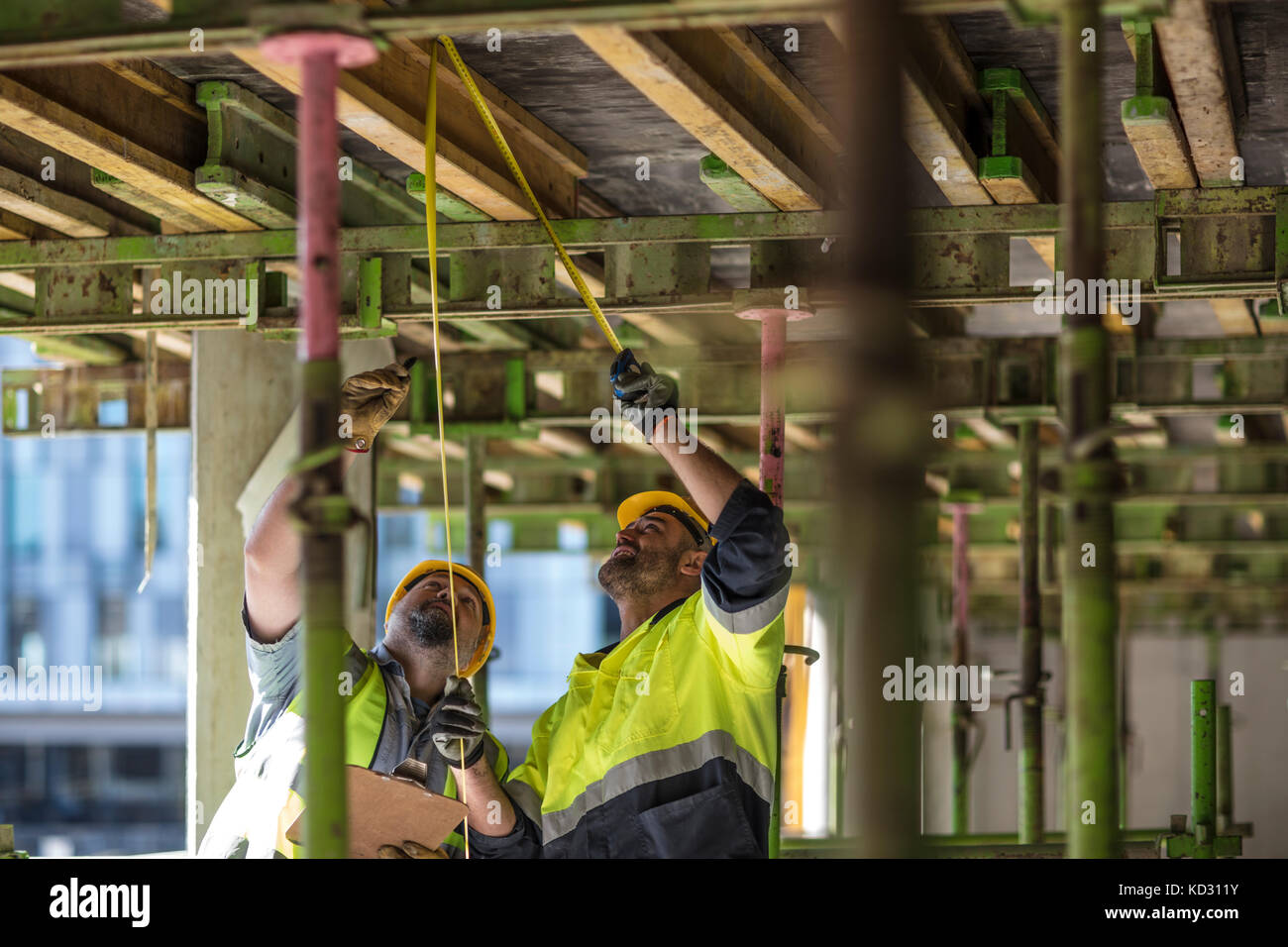 Construction workers measuring building Stock Photo - Alamy