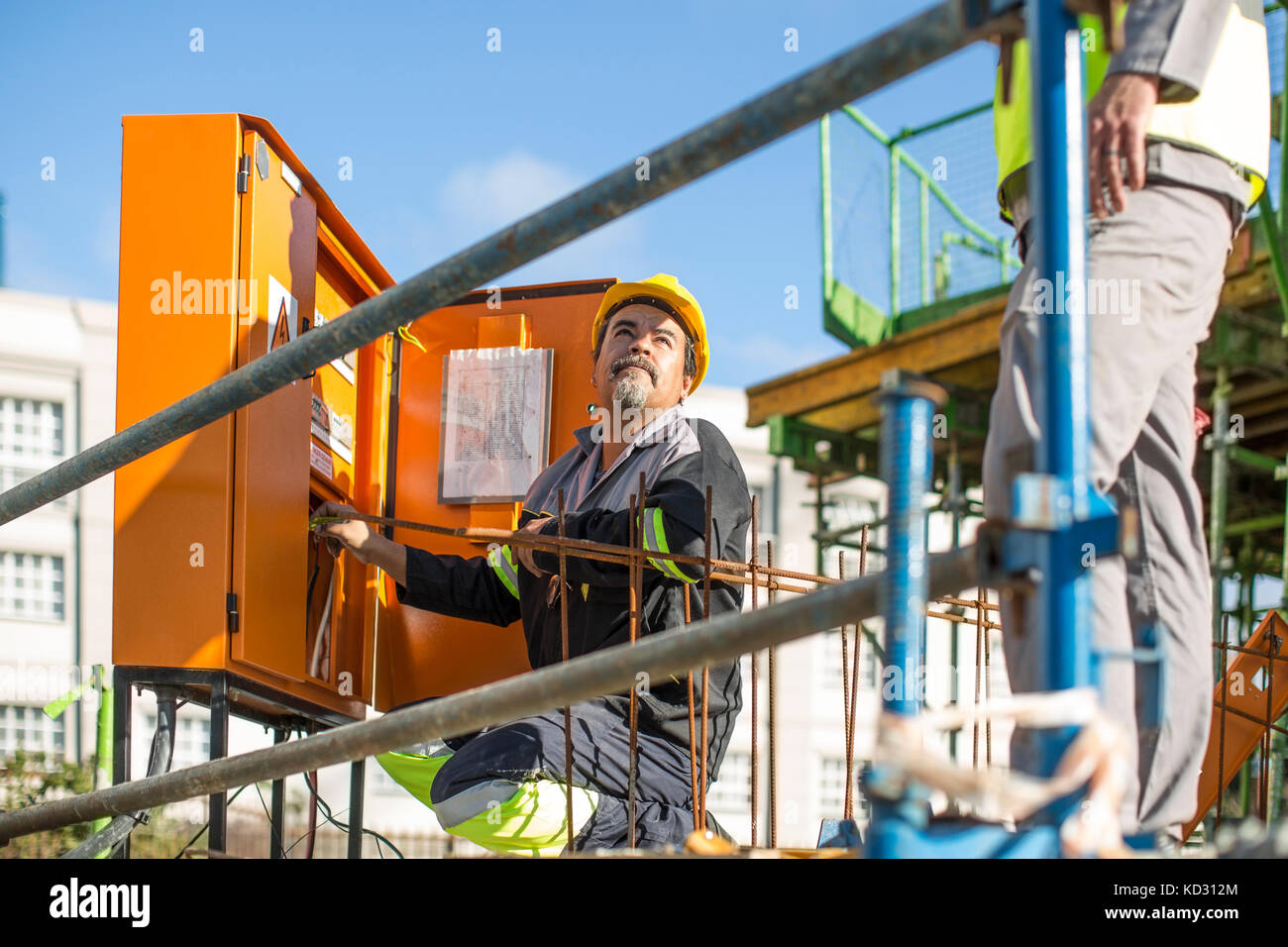Construction worker checking machine Stock Photo - Alamy