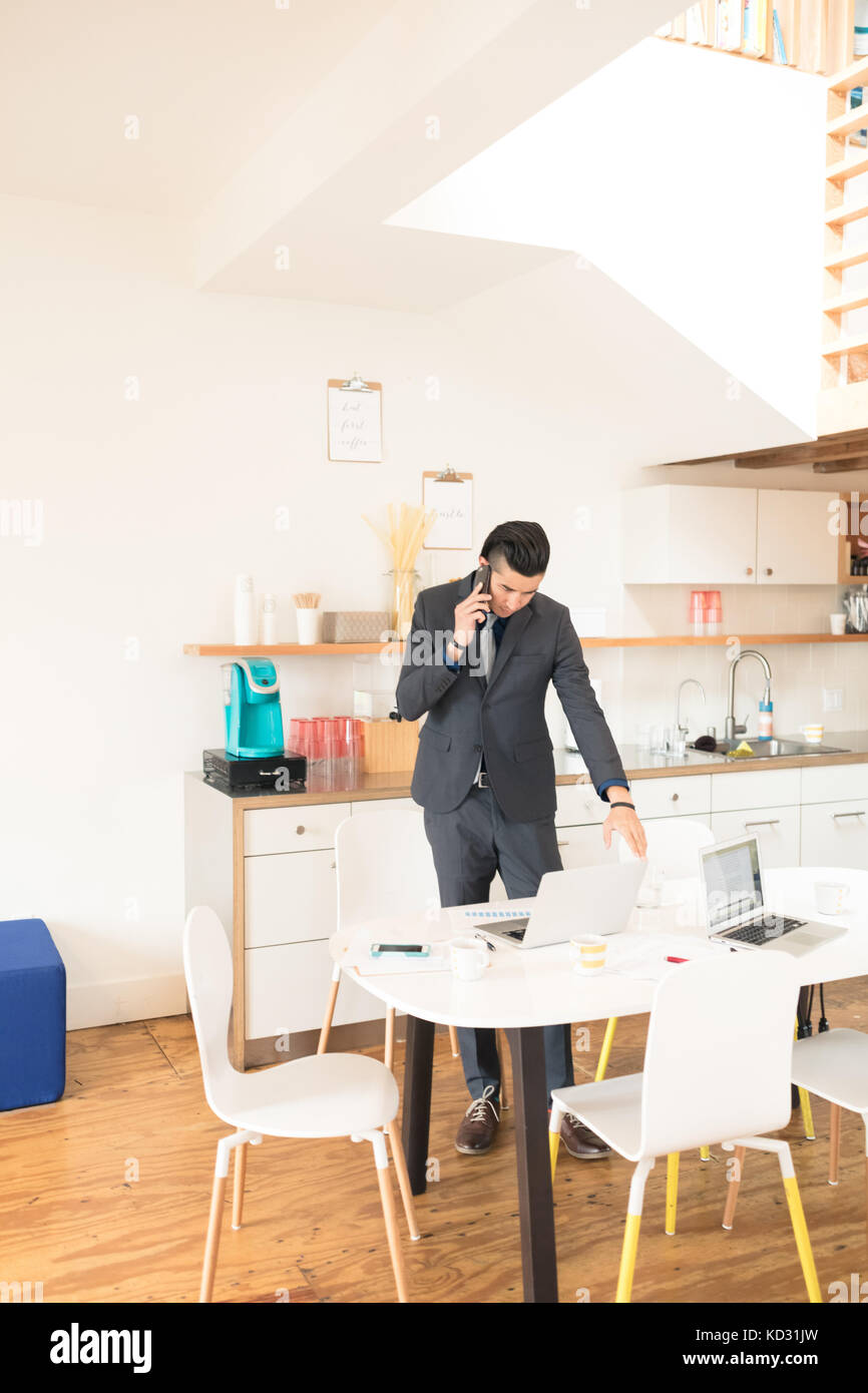 Young businessman making smartphone call at office table Stock Photo ...