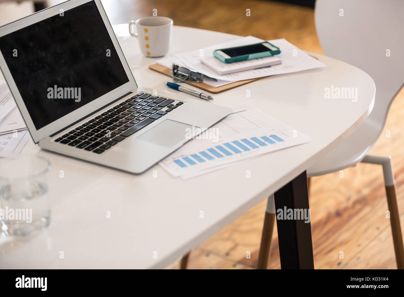 Laptop, bar chart and smartphone on office desk Stock Photo - Alamy