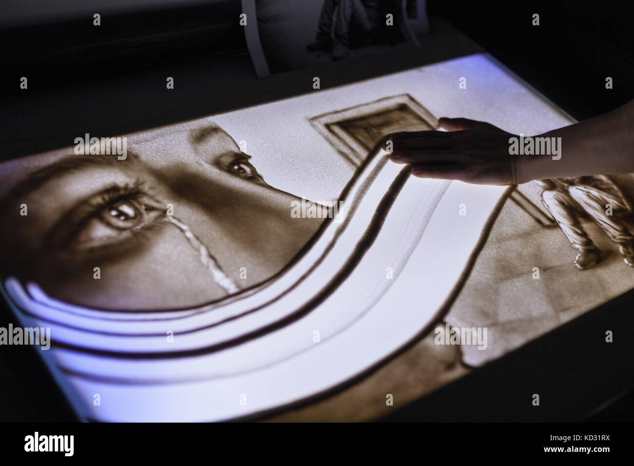 Hand of man wiping away sand drawing of woman crying, Cagliari ...